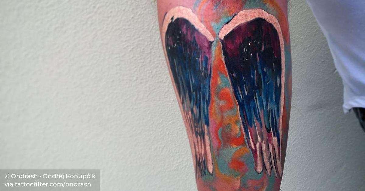 Abstract angel tattoo on the right inner forearm.