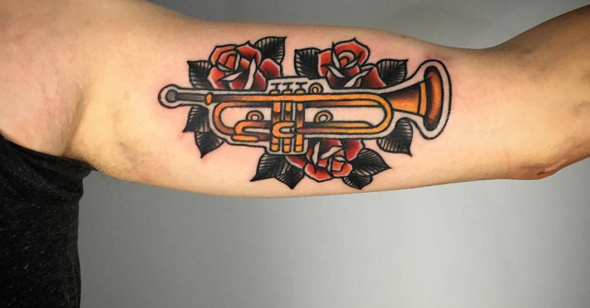 Traditional style trumpet tattoo on the left inner arm.