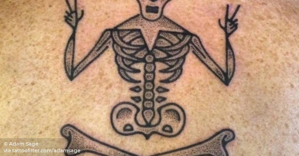 Hand poked happy skeleton tattoo on the upper back.