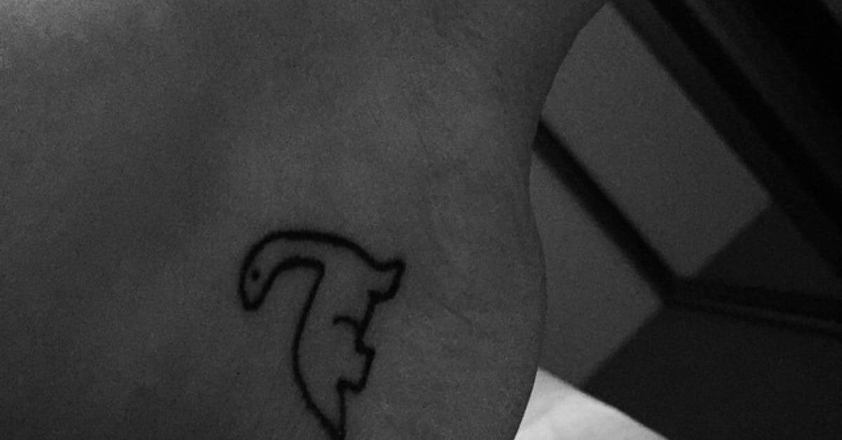 Ankle tattoo of a brontosaurus on Nat White.