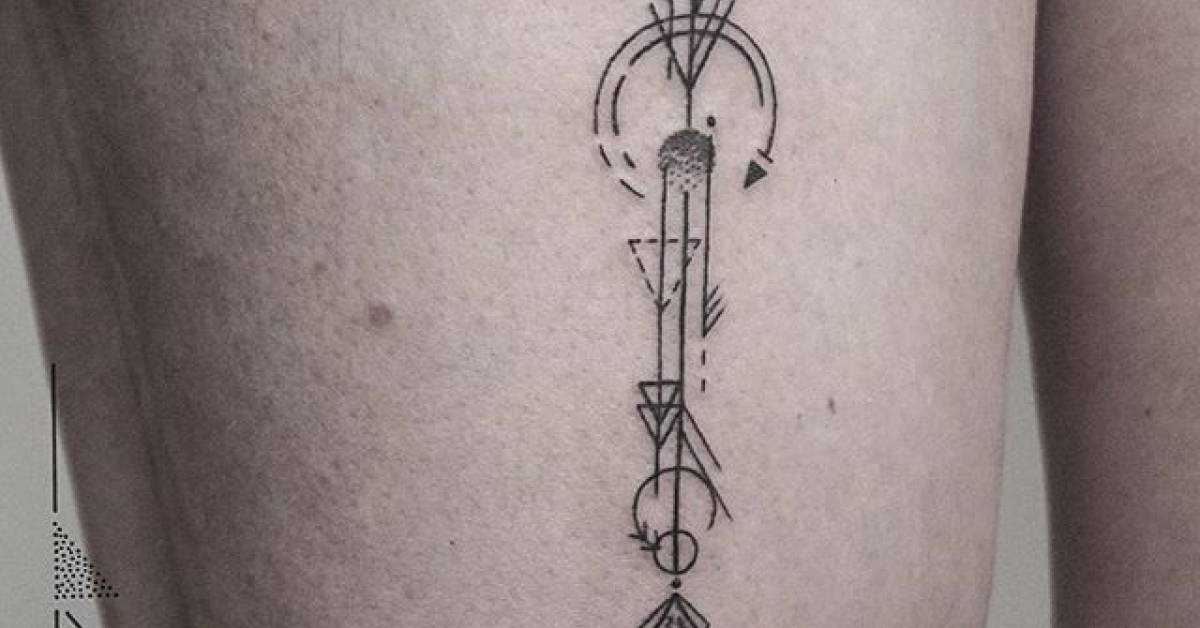 Geometric arrow tattoo on the thigh.