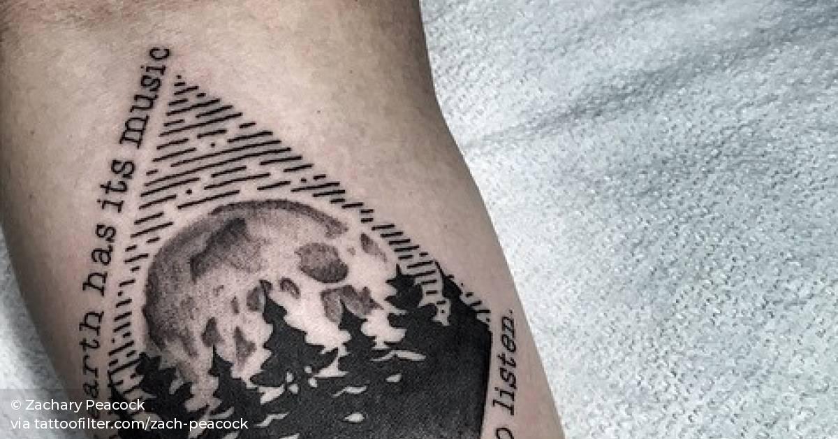 Night forest tattoo on the right inner arm, surrounded