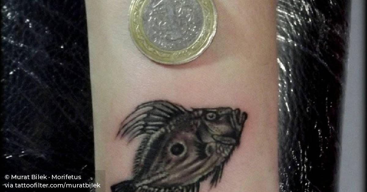 Wrist tattoo of a fish by Murat Bilek.