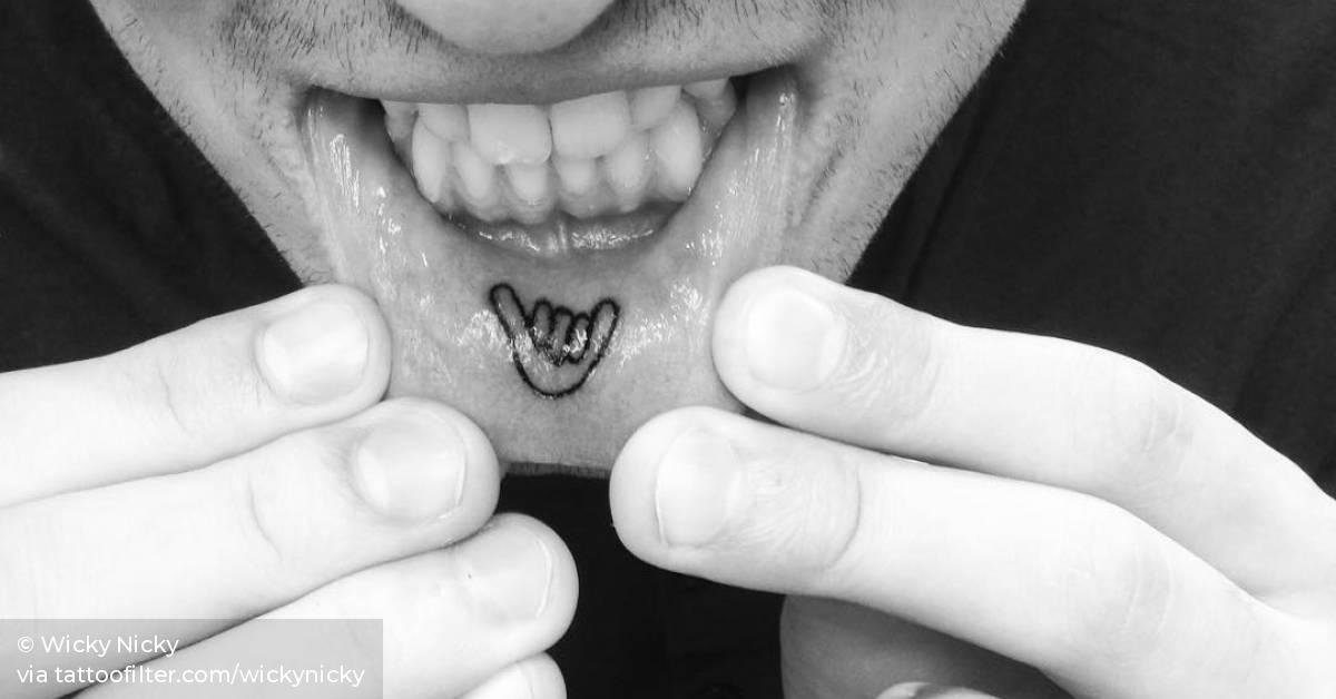 Shaka sign tattoo on the lip.