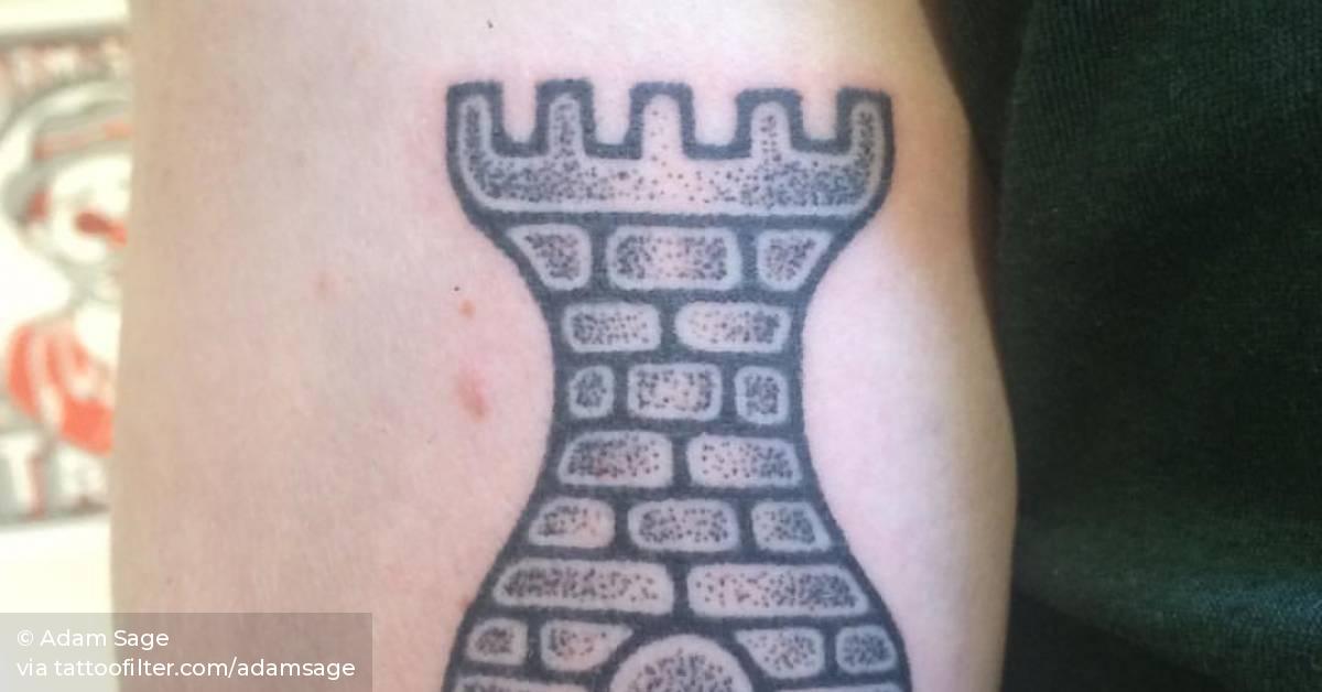 Hand poked castle tattoo on the back of the left arm.