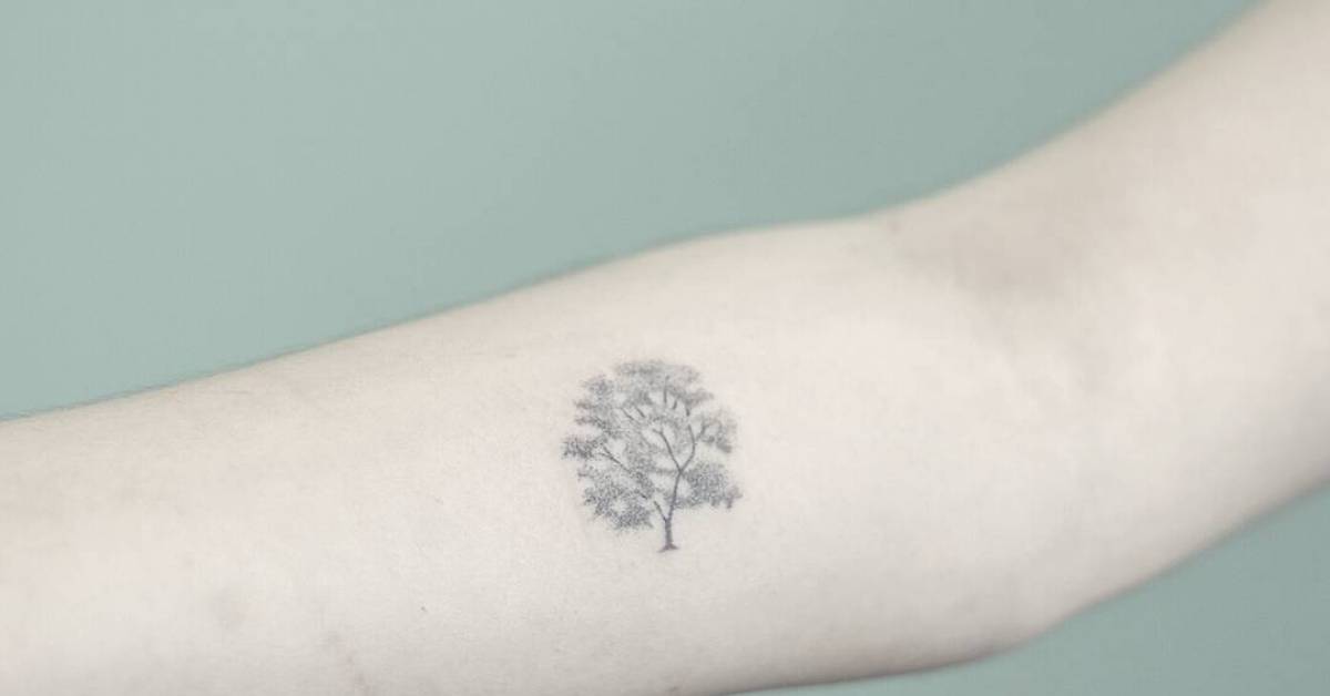 Hand poked tree tattoo on the right inner forearm.