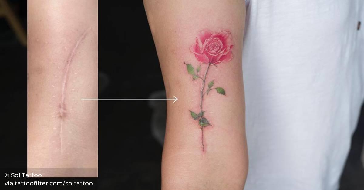 Pink rose scar cover tattoo on the right bicep.