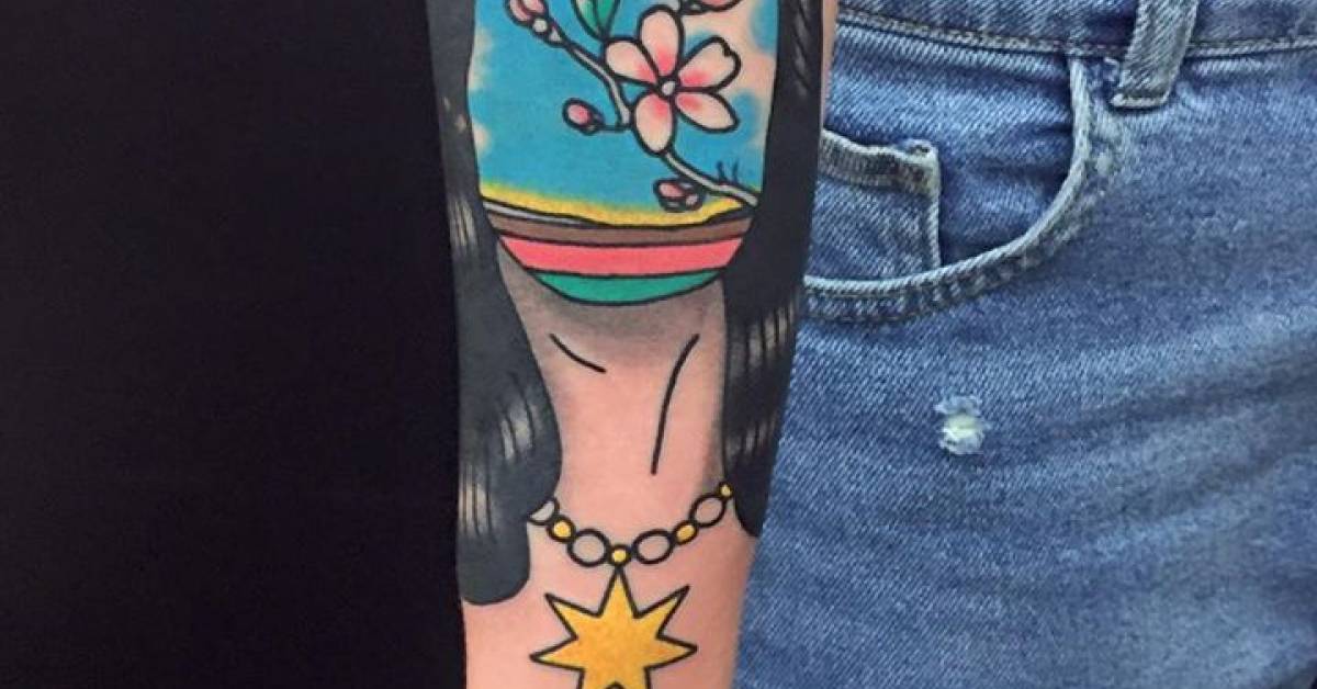 Surrealist portrait tattoo on the right inner arm.