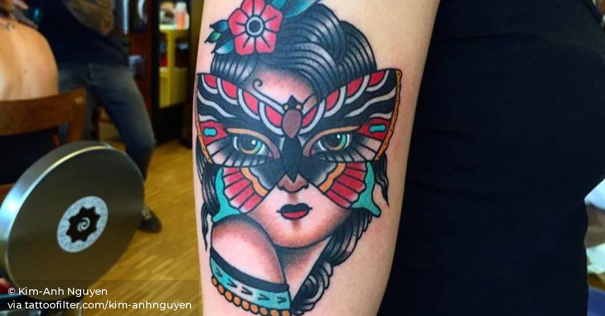 Traditional style woman with butterfly mask tattoo on
