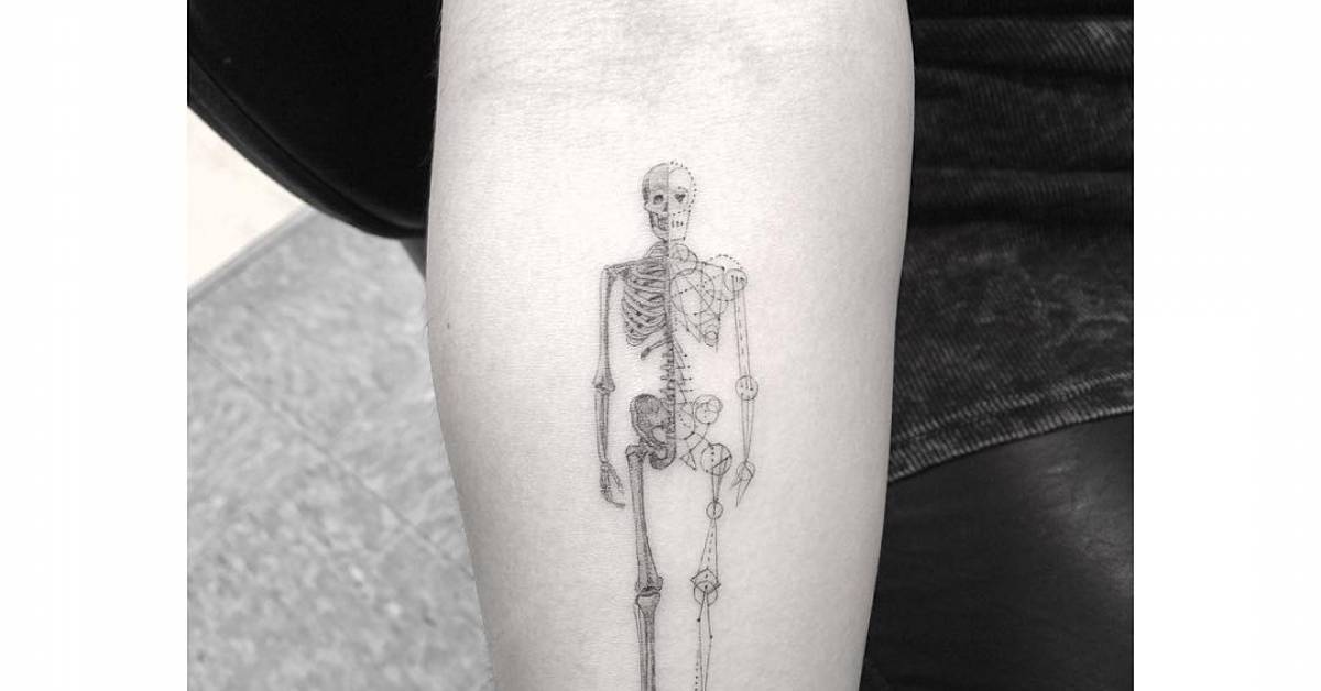 Fine line skeleton tattoo on the right inner forearm.