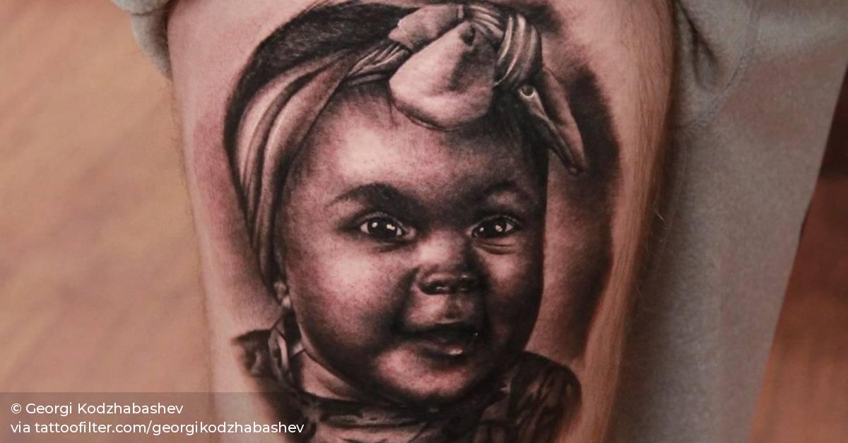 Black and grey baby portrait tattoo on the right thigh.