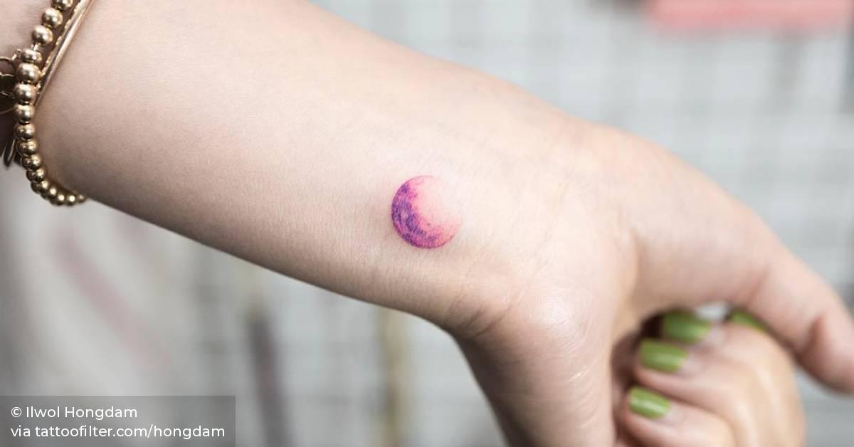 Purple moon tattoo on the left inner wrist.