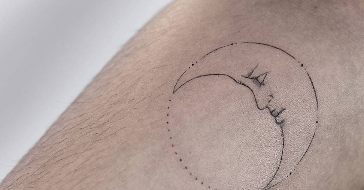 Fine line moon tattoo on the right inner forearm.