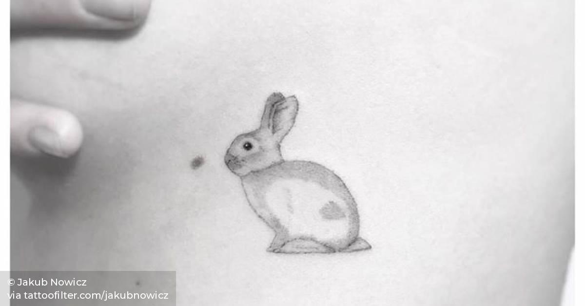 Fine line rabbit tattoo on the left side ribcage.
