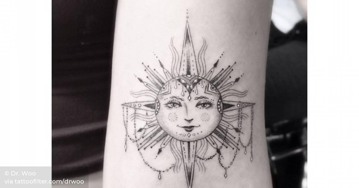Ornamental fine line sun tattoo on the left bicep.