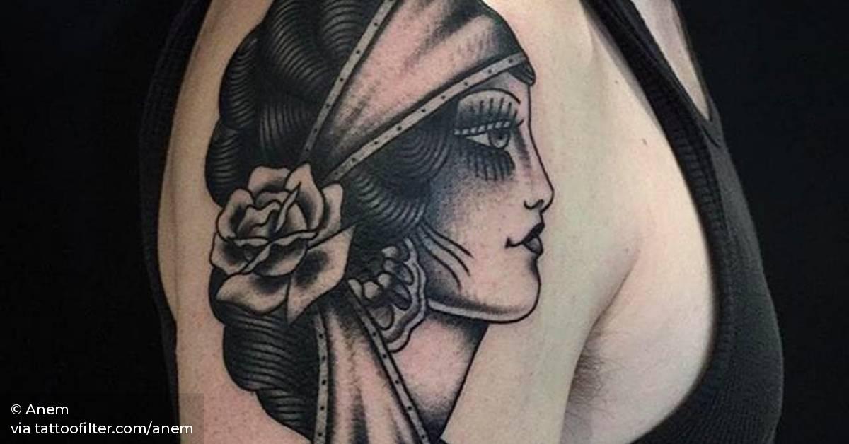 Traditional style lady head tattoo on the upper arm.