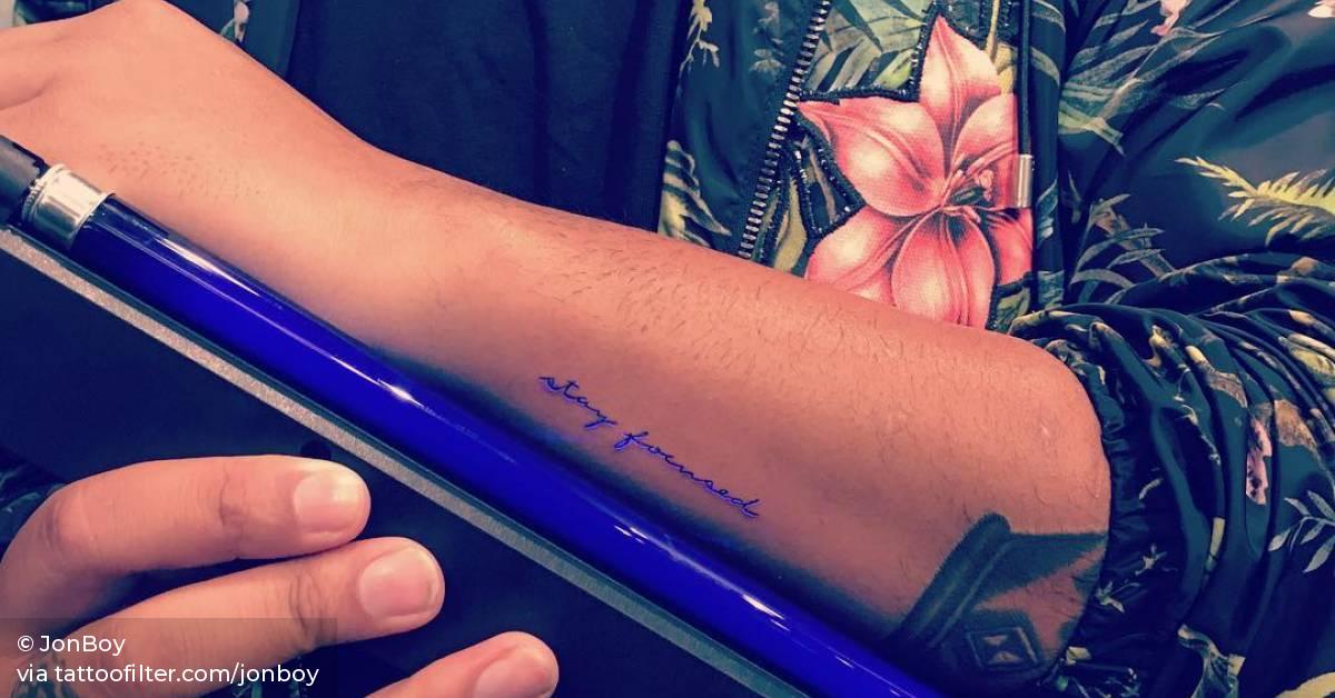 "Stay focused" tattoo on the left forearm.