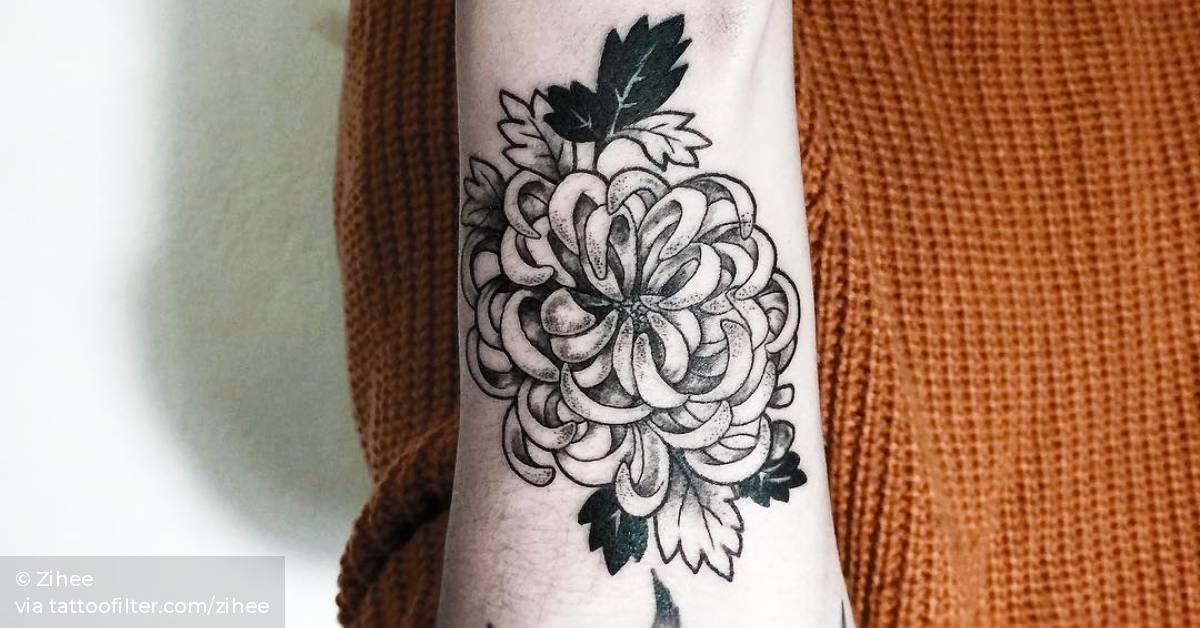 Blackwork chrysanthemum tattoo on the right forearm.