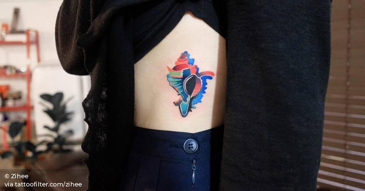 Sea snail tattoo on the left side ribcage.