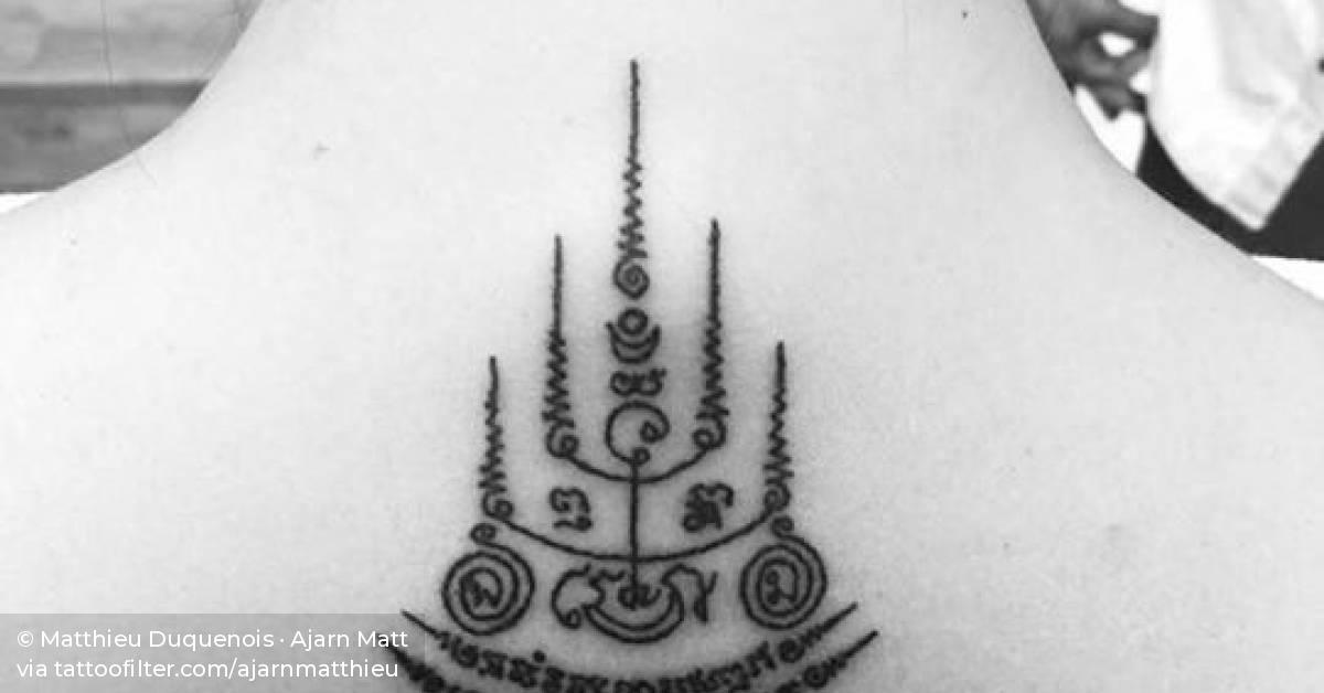 Sak Yant style tattoo on the upper back.