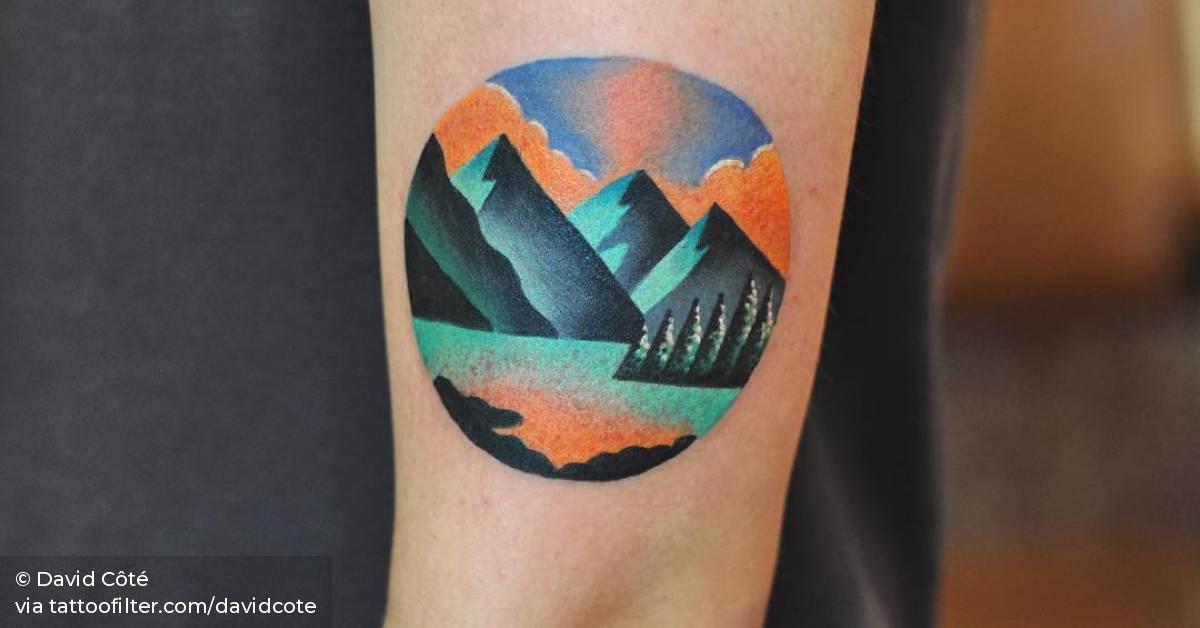 Mountain landscape tattoo on the left upper arm.