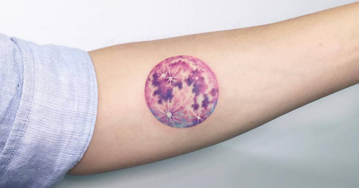 Pink moon tattoo on the right inner forearm.