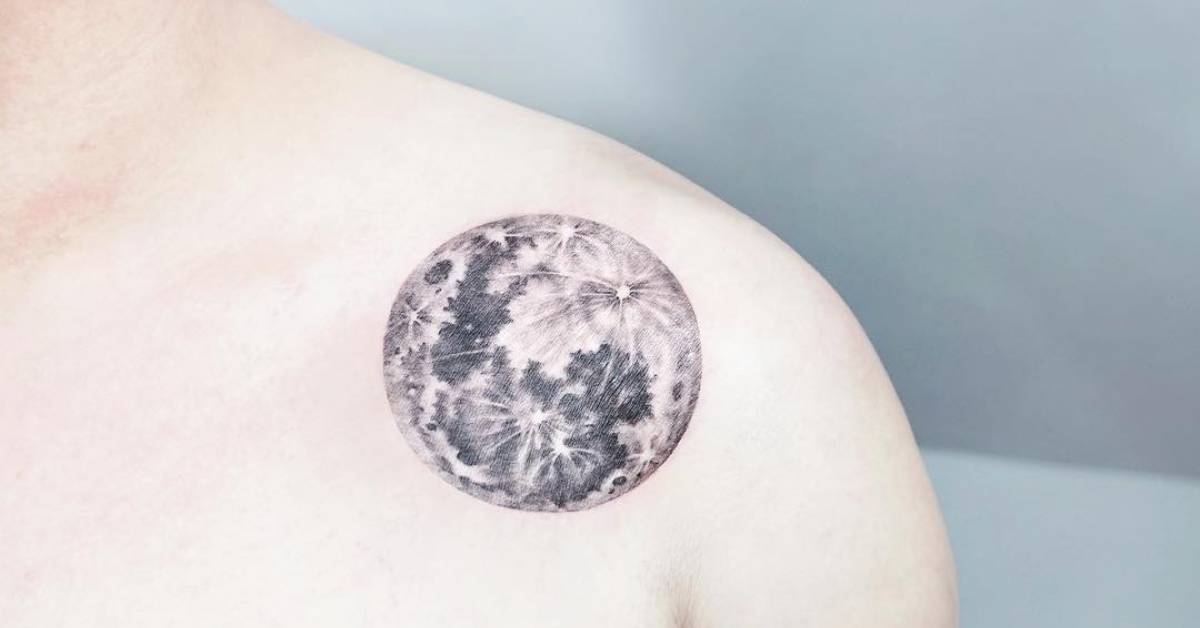 Realistic moon tattoo on the left shoulder.