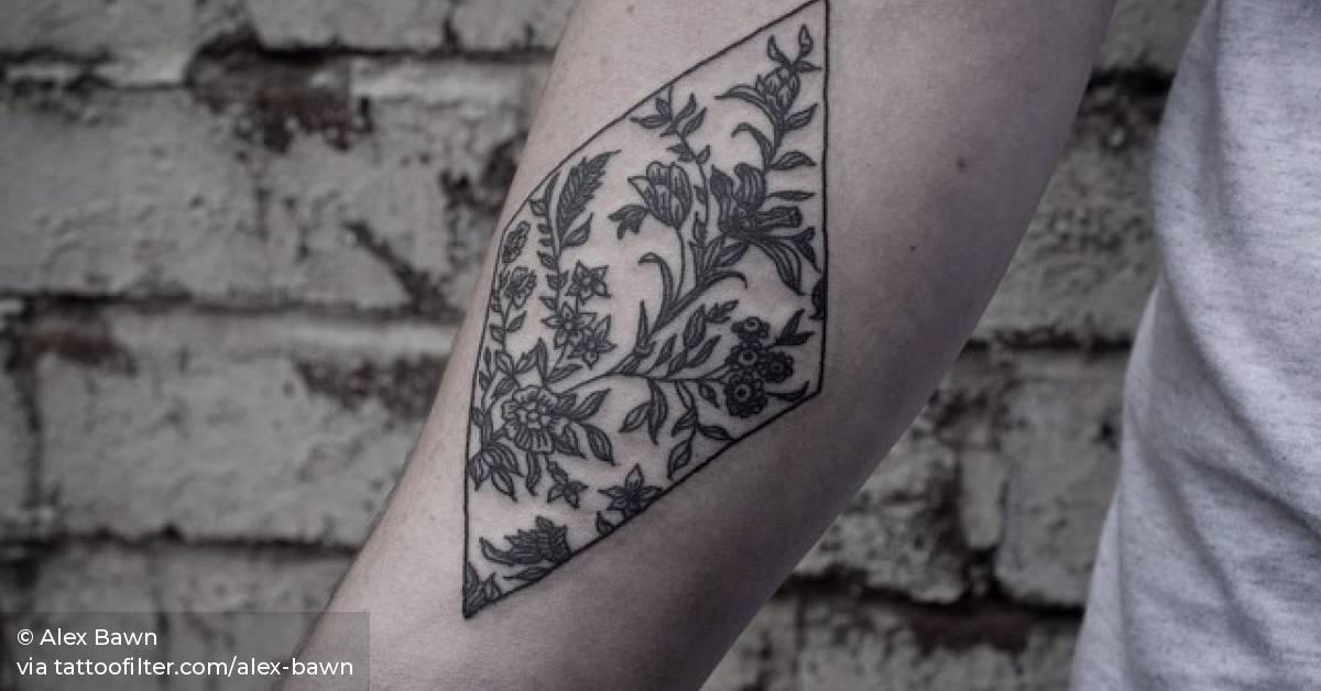 Floral rhombus tattoo on the right inner forearm.