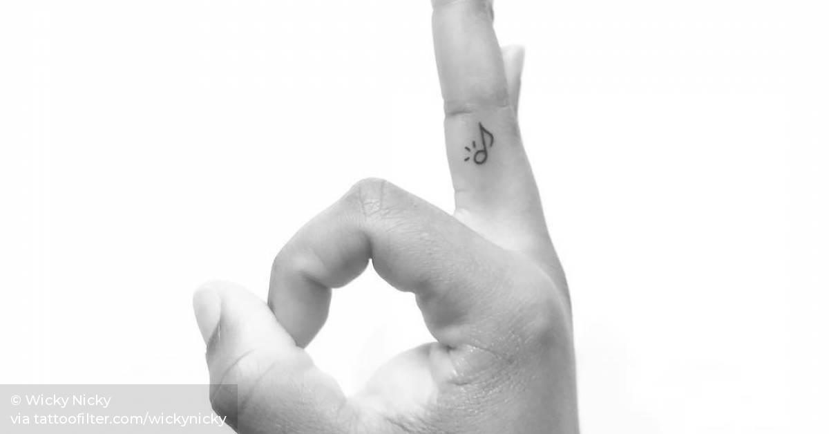 Music note tattoo on the middle finger.
