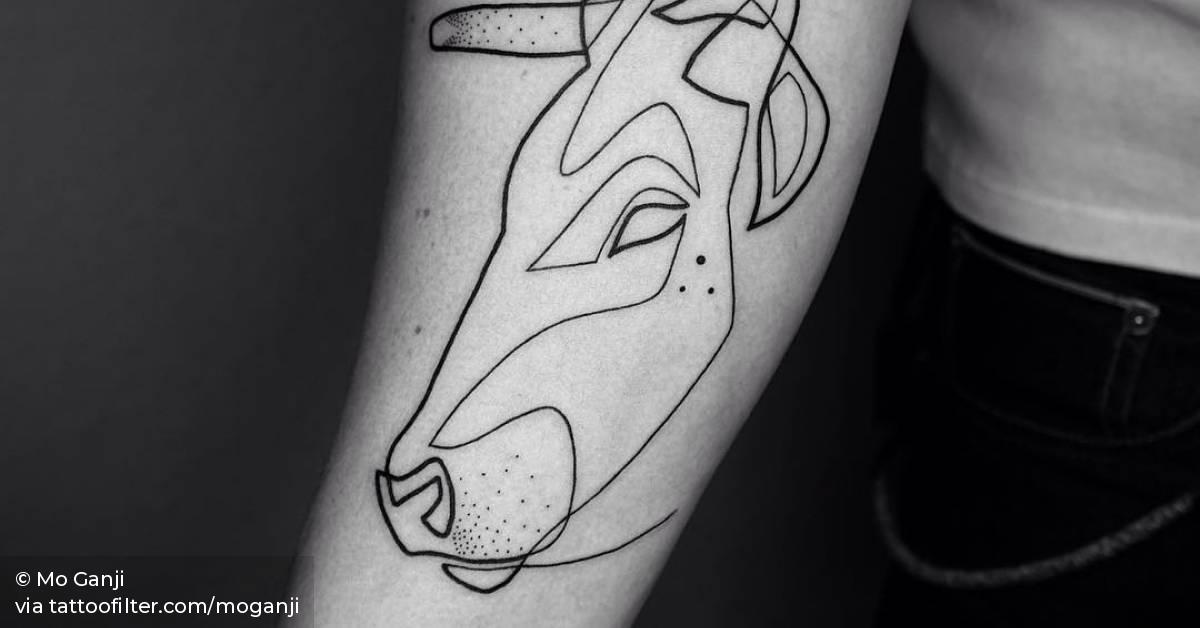 Continuous line cow tattoo on the right inner forearm.
