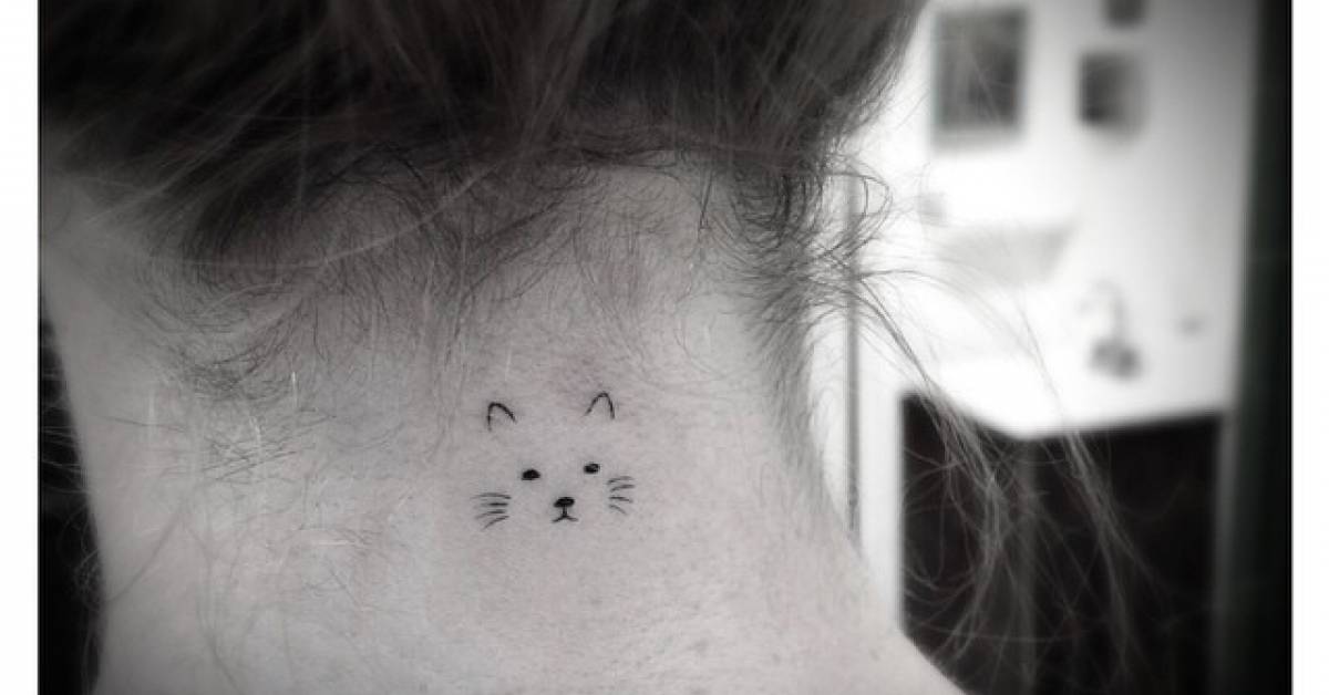 Minimalist cat face tattoo on the back of the neck.