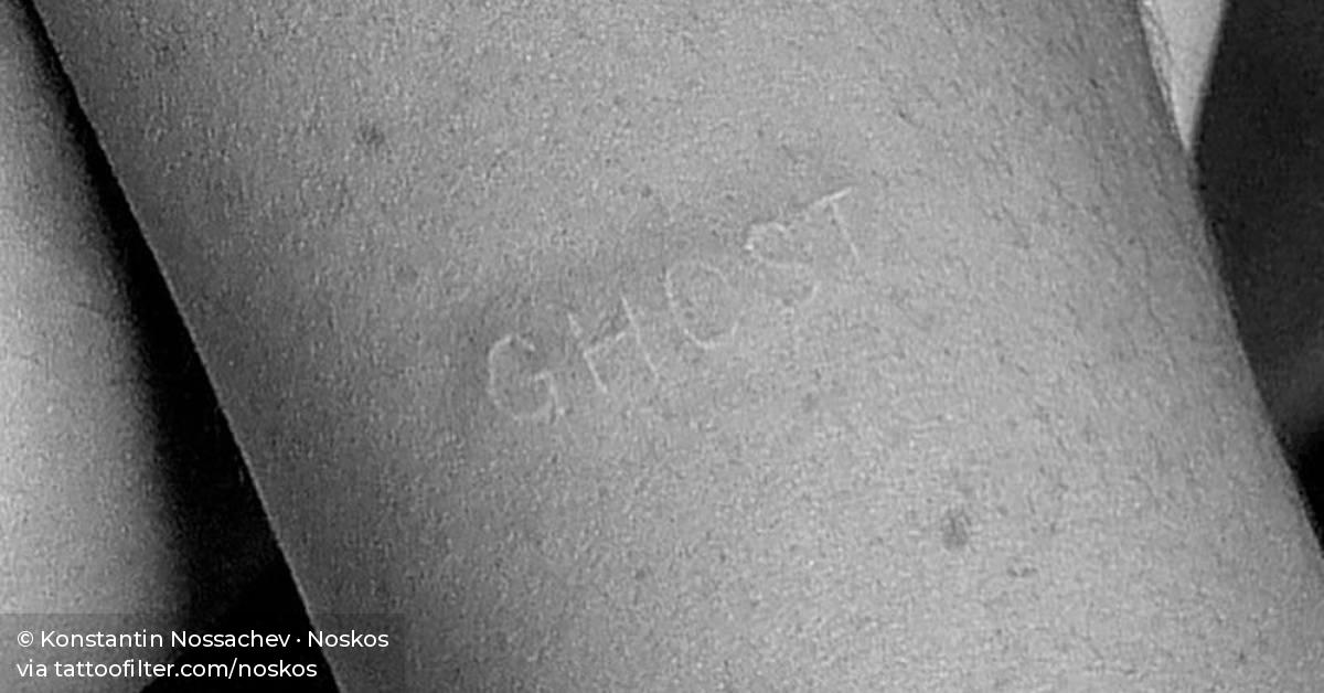 White ink “GHOST” tattoo.