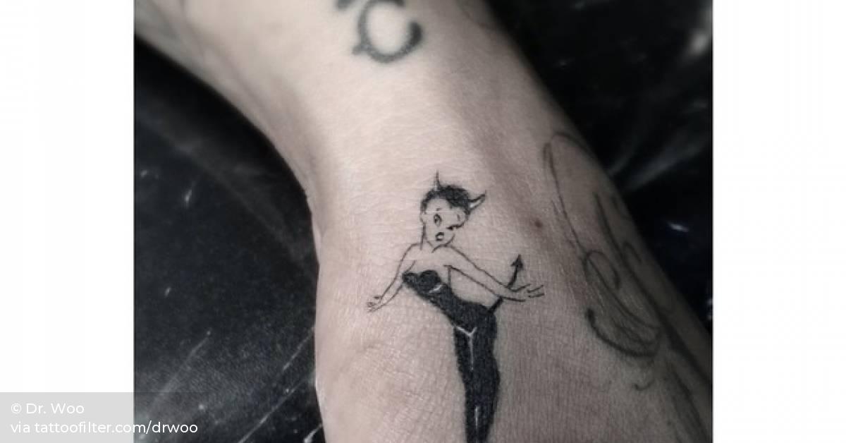 Cheeky she-devil tattoo on the left hand.