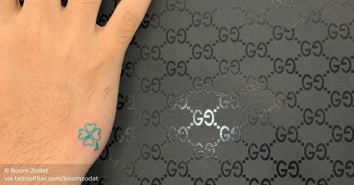 Small green clover tattoo on the right hand.