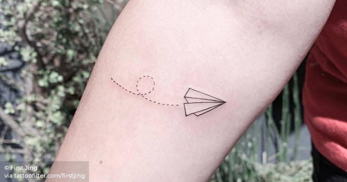 Paper plane tattoo on the inner forearm.