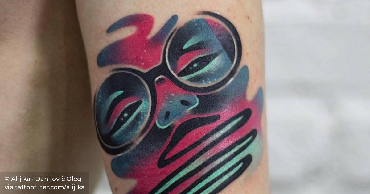 Psychedelic face tattoo on the left upper arm.
