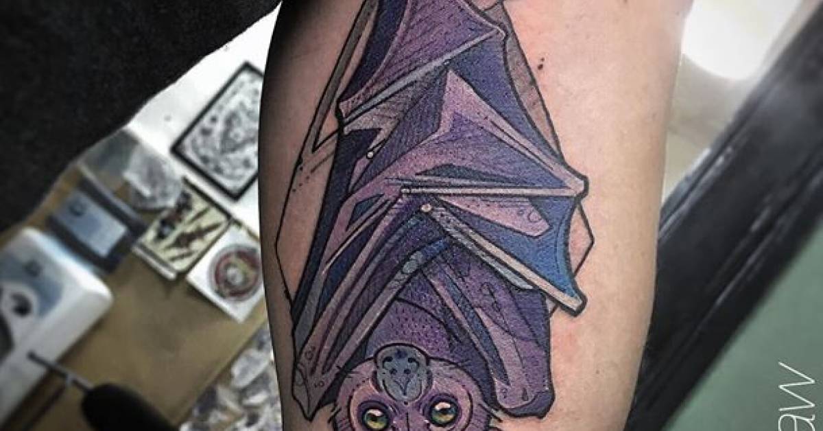 Upside down bat tattoo on the left inner arm.