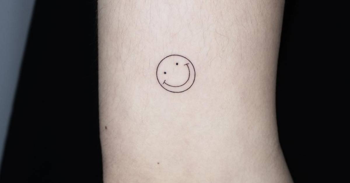 Smiley tattoo on the upper arm.