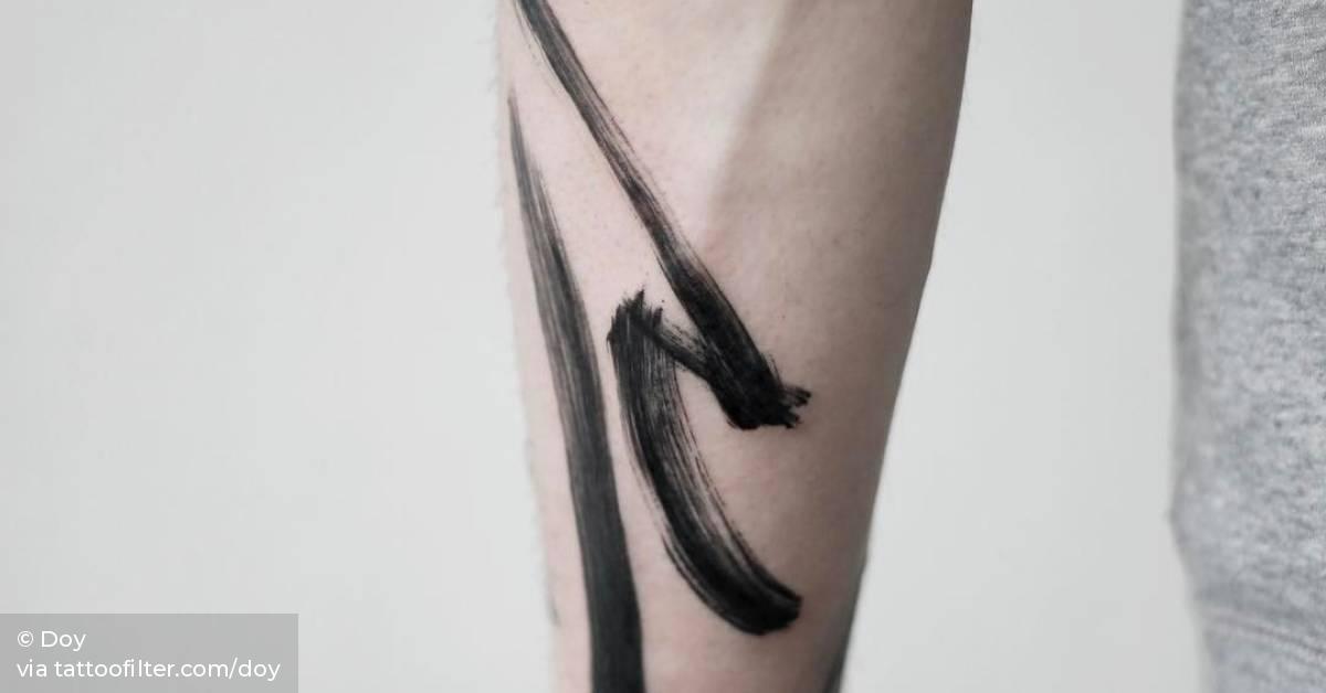 Abstract calligraphy tattoo on the left forearm.