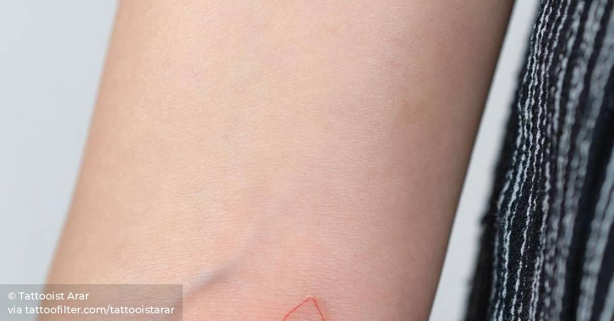 Conventional red ink heart tattoo on the wrist.