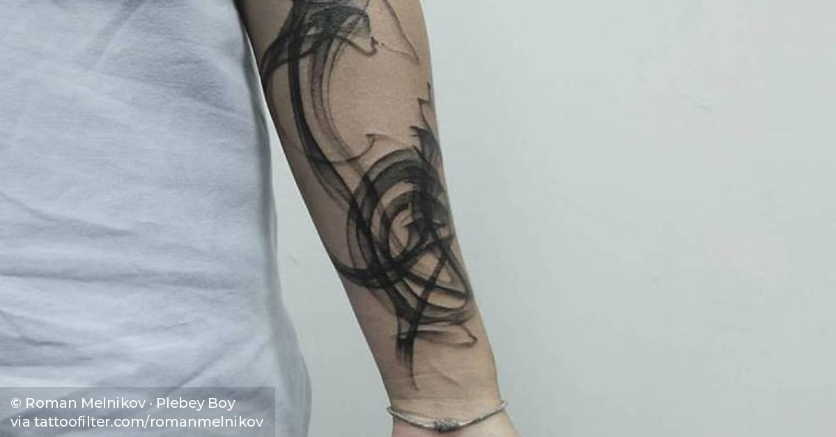 Smoke like tattoo on the left inner forearm.