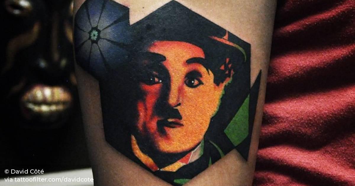 Charlie Chaplin portrait tattoo on the right upper arm.
