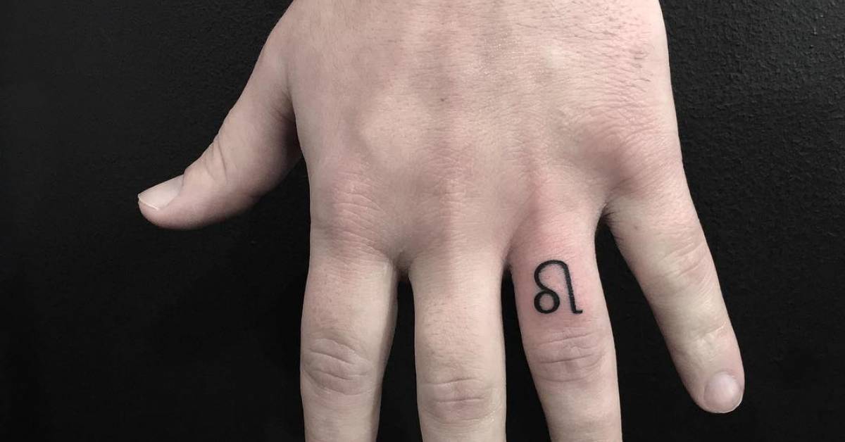 Leo Zodiac sign tattoo on the ring finger.