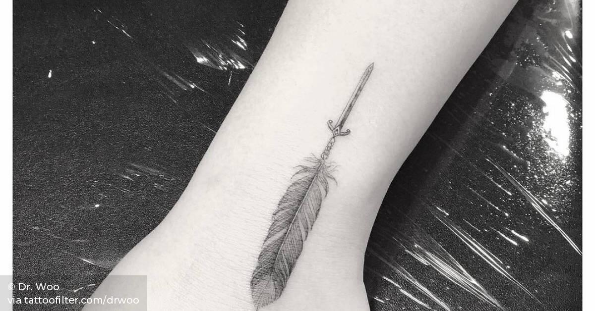Fine line feather tattoo on the left wrist.