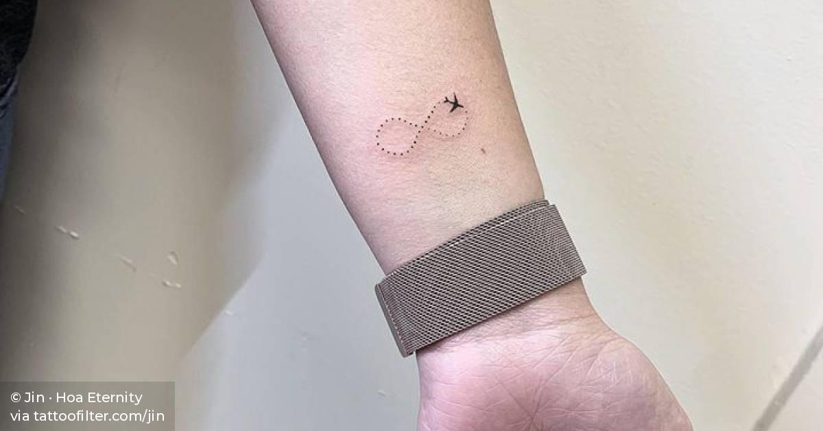 Infinity airplane tattoo on the inner forearm.