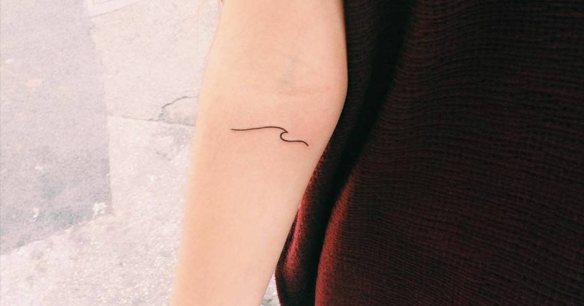 Small minimalist wave tattoo on Emanuelle.