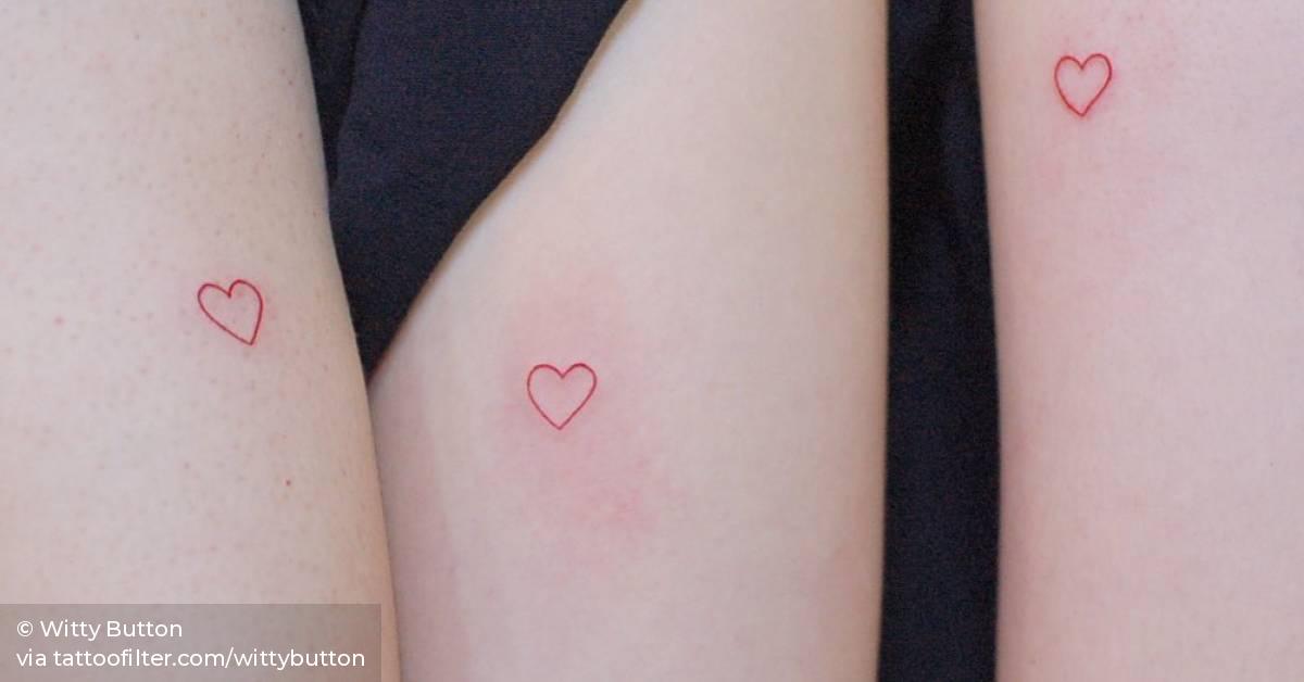 Matching red ink heart tattoos.