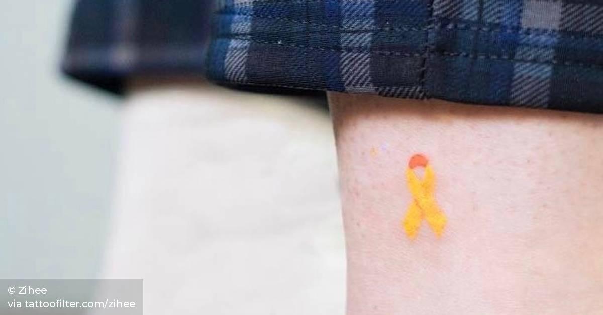 Yellow ribbon tattoo on the ankle.