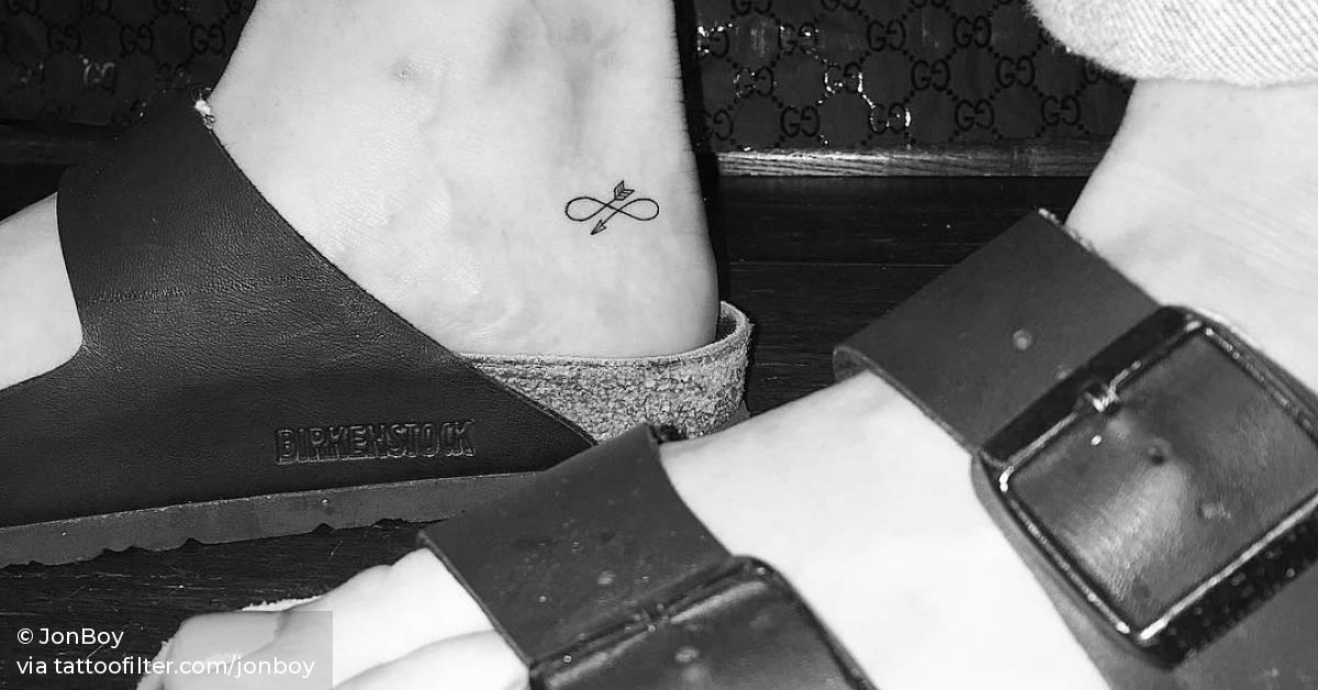 Infinity arrow tattoo on the inner ankle.