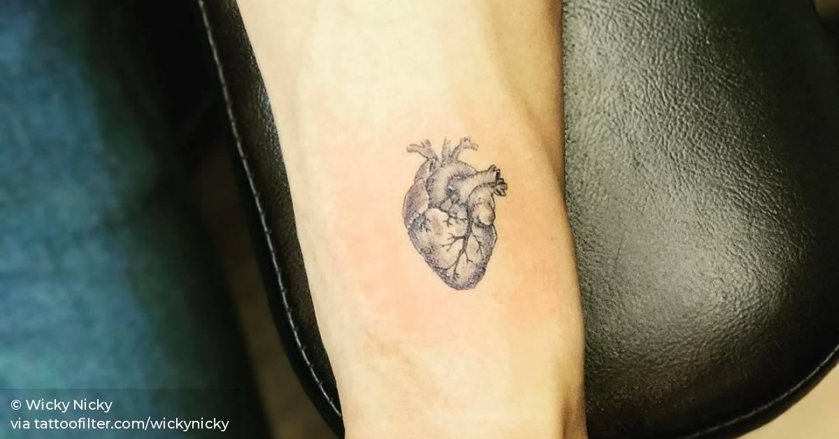 Fine line anatomical heart tattoo on the left inner